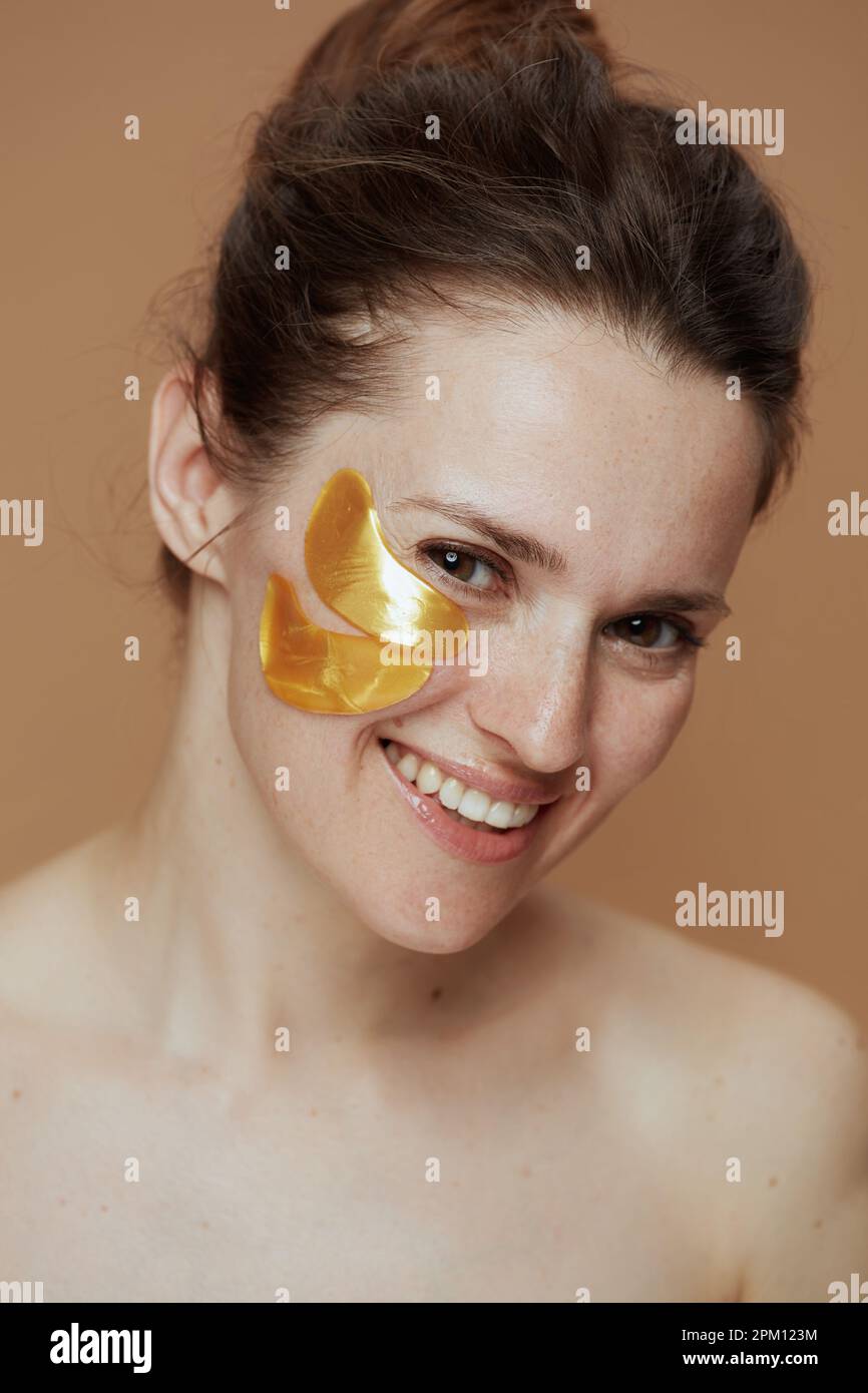 happy modern female with eye patches on beige background Stock Photo ...