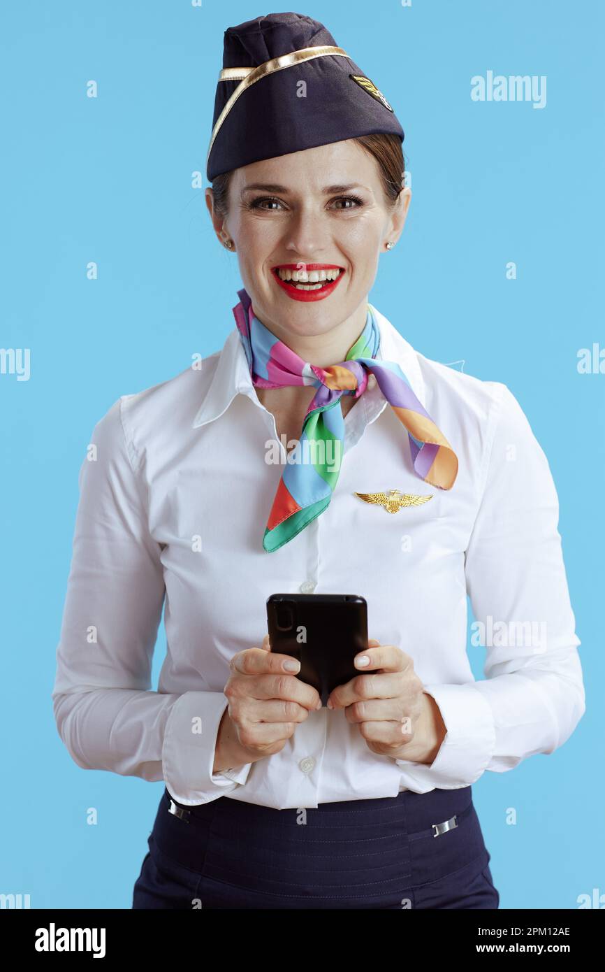 smiling modern air hostess woman against blue background in uniform ...
