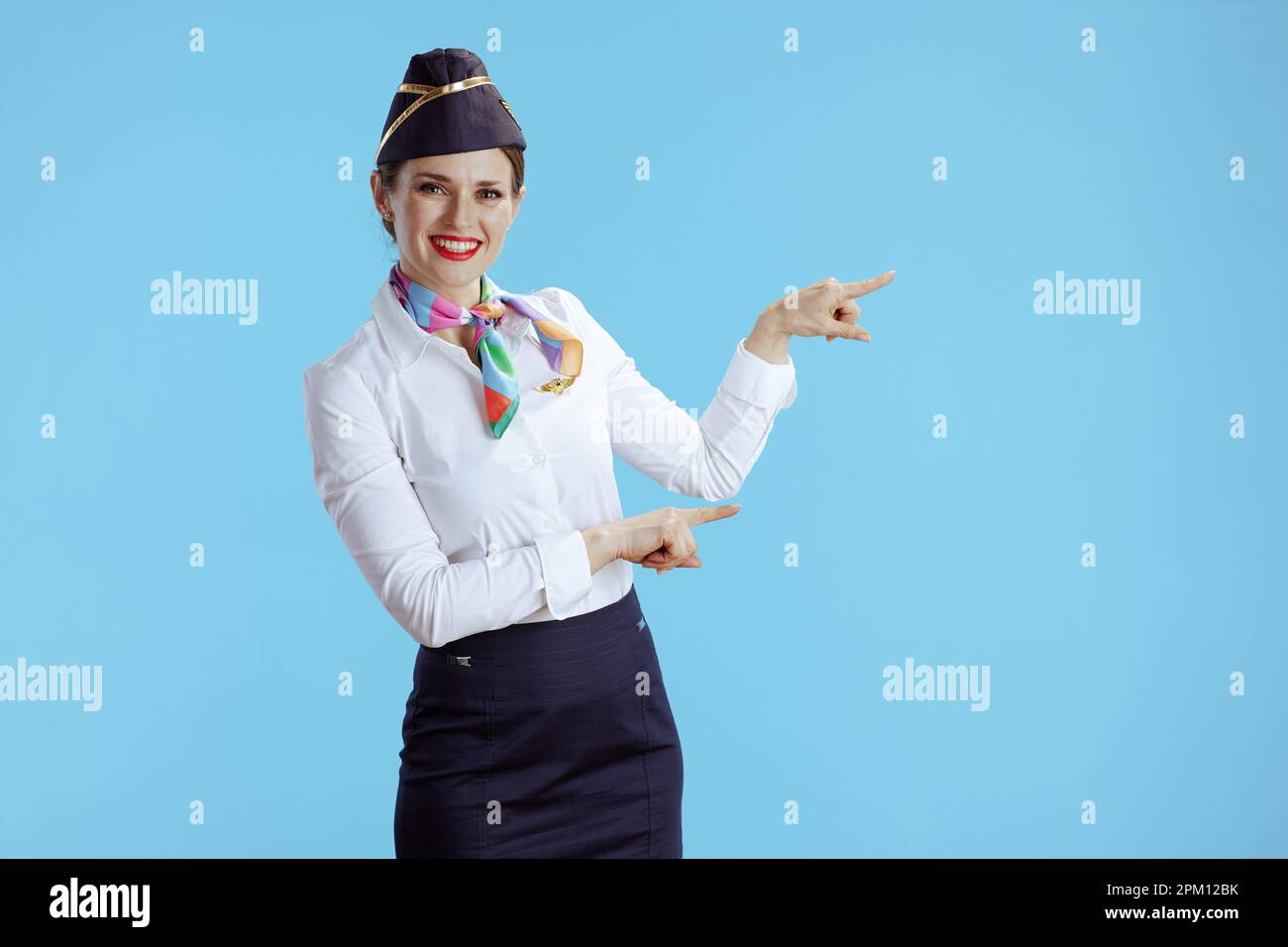 smiling elegant air hostess woman on blue background in uniform ...