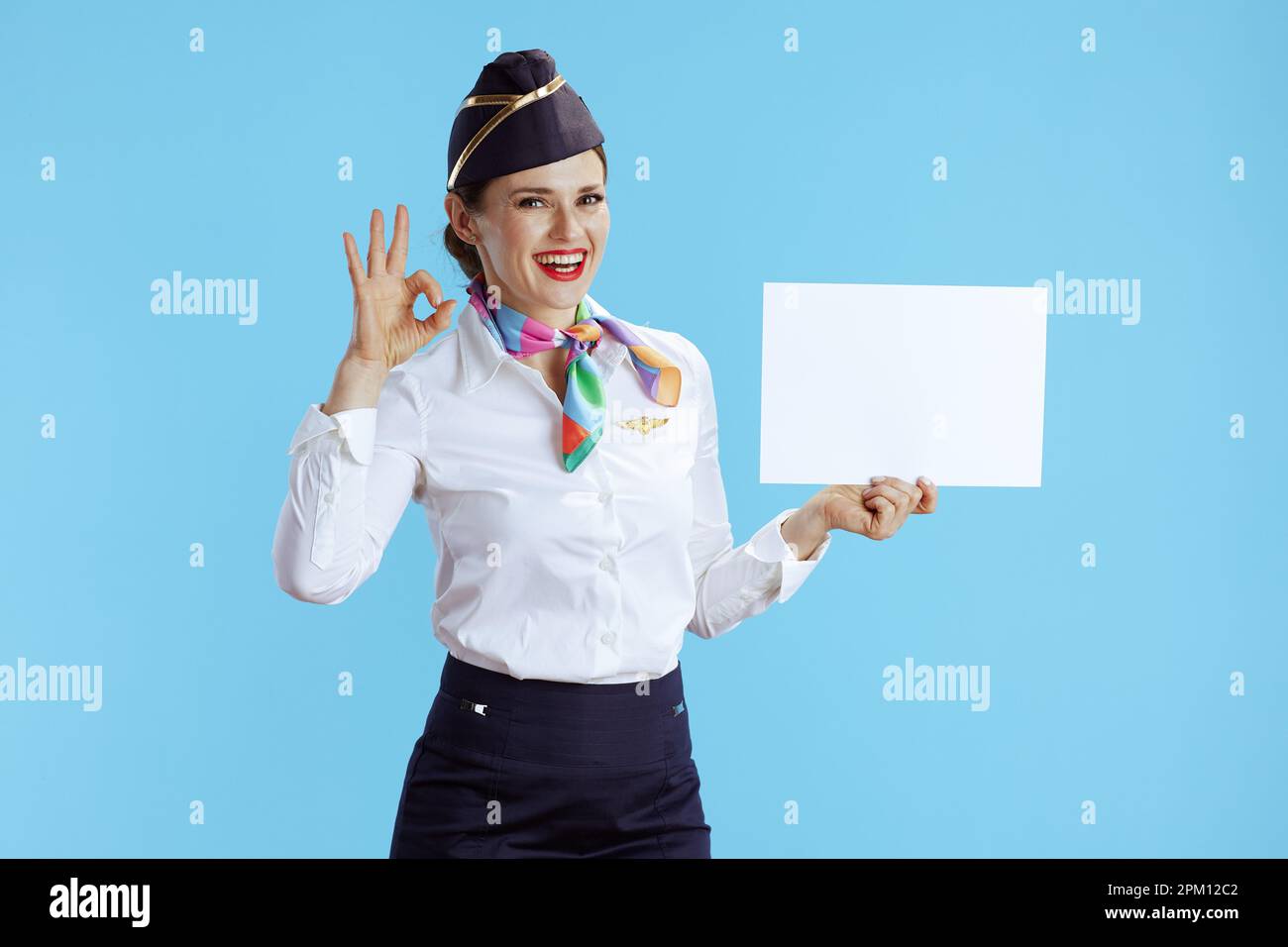 smiling modern female air hostess against blue background in uniform ...