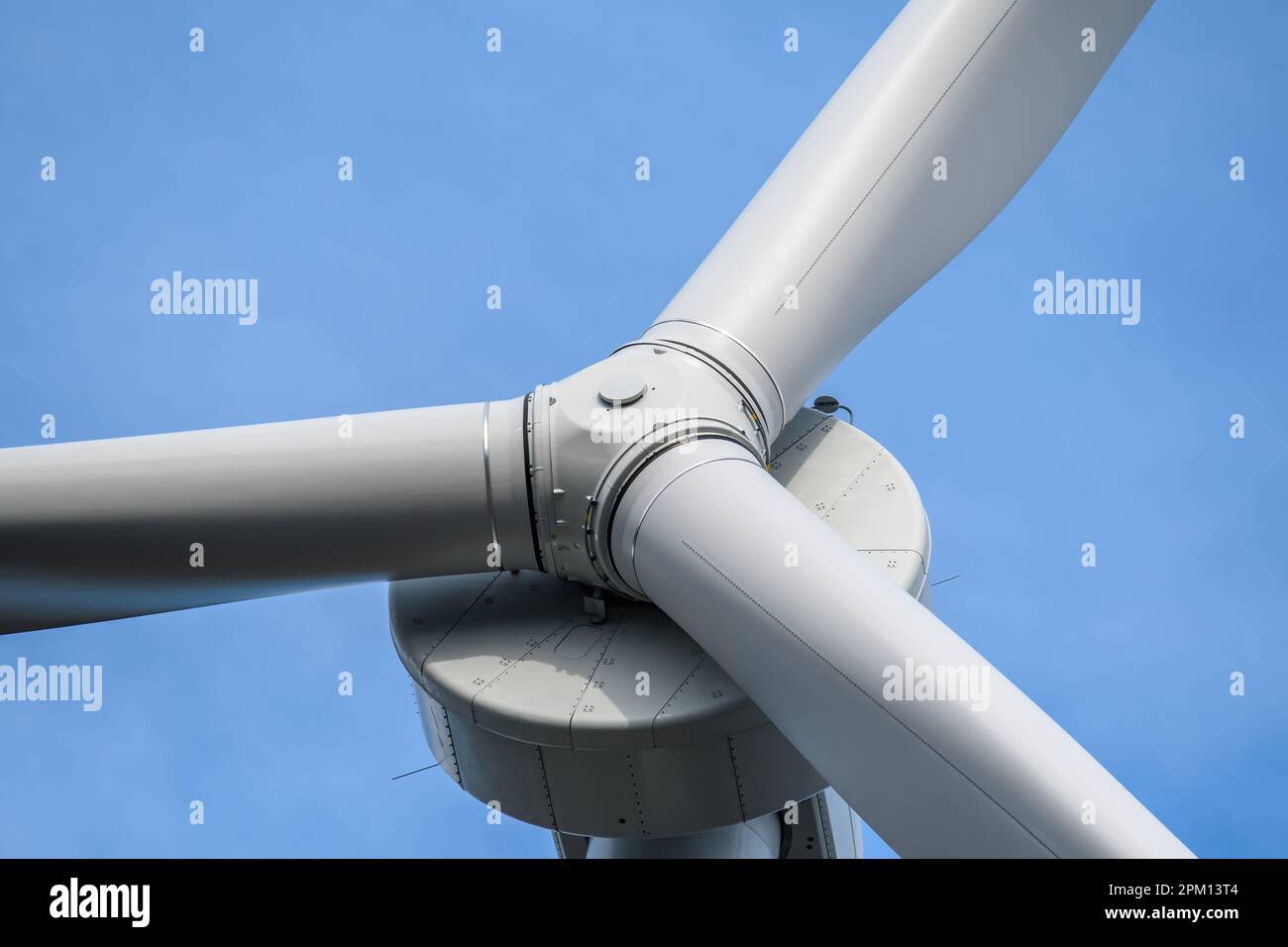 Closeup of the hub of a large wind turbine, looking up at an angle ...