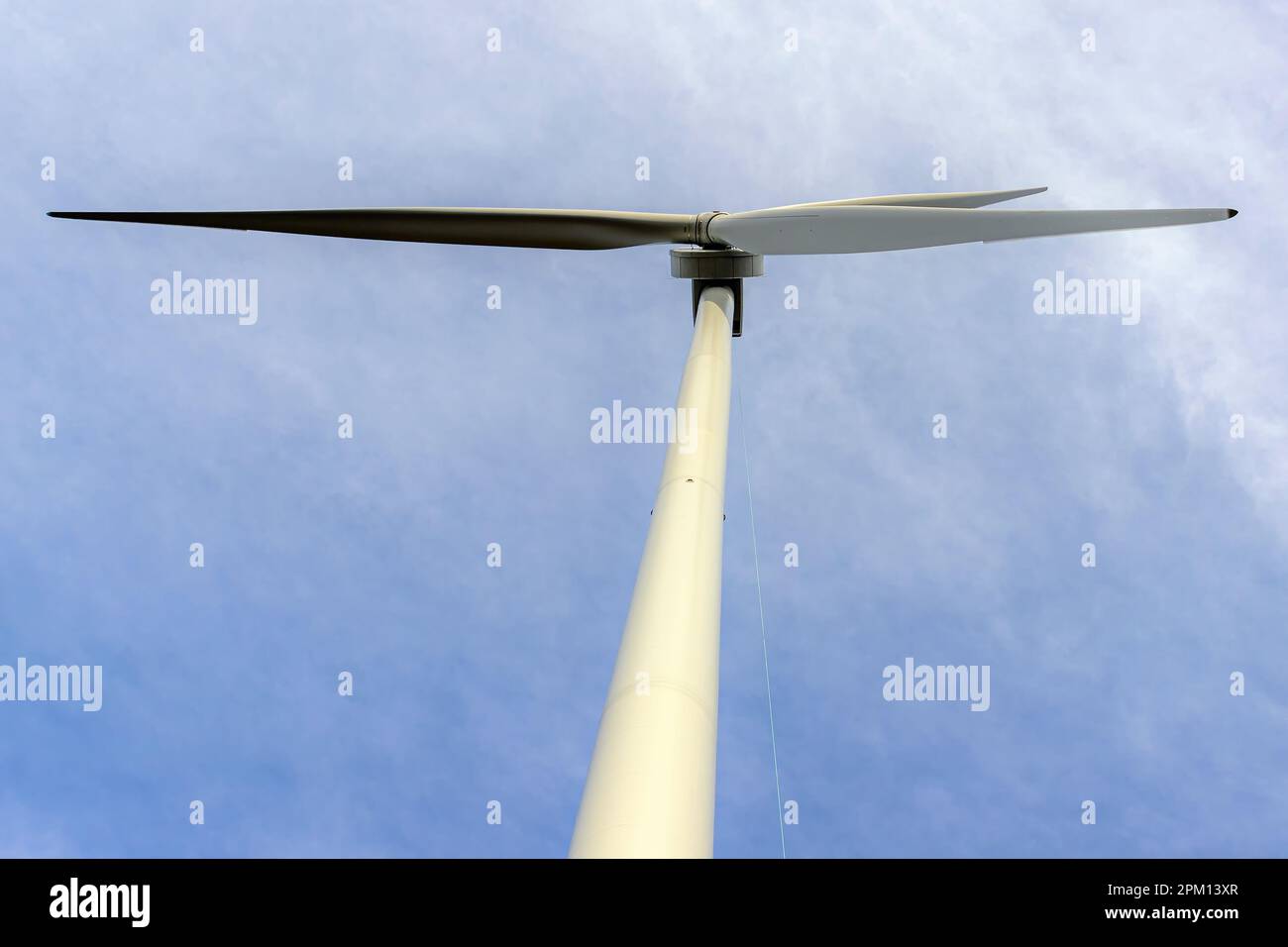 Looking almost directly up at the blades of a wind turbine from under ...