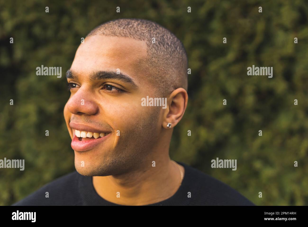 Close portrait of smiling young African American man with a buzz cut ...