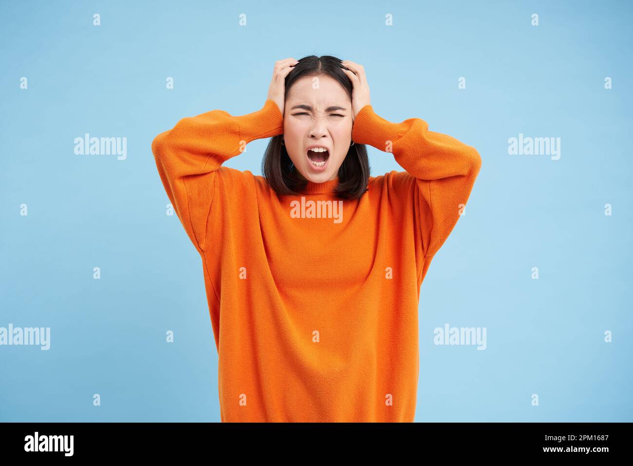 Angry korean girl, shouts and shakes from anger, stands frustrated and ...