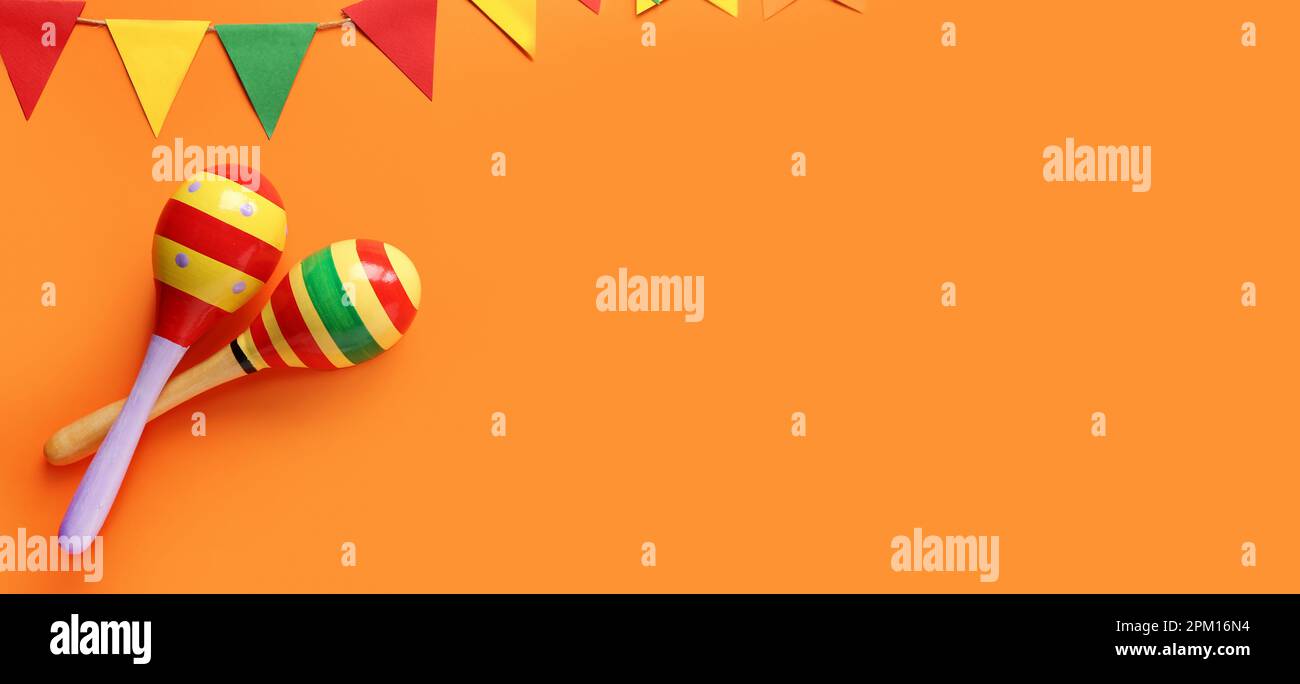 Maracas and Mexican garland on orange background with space for text ...