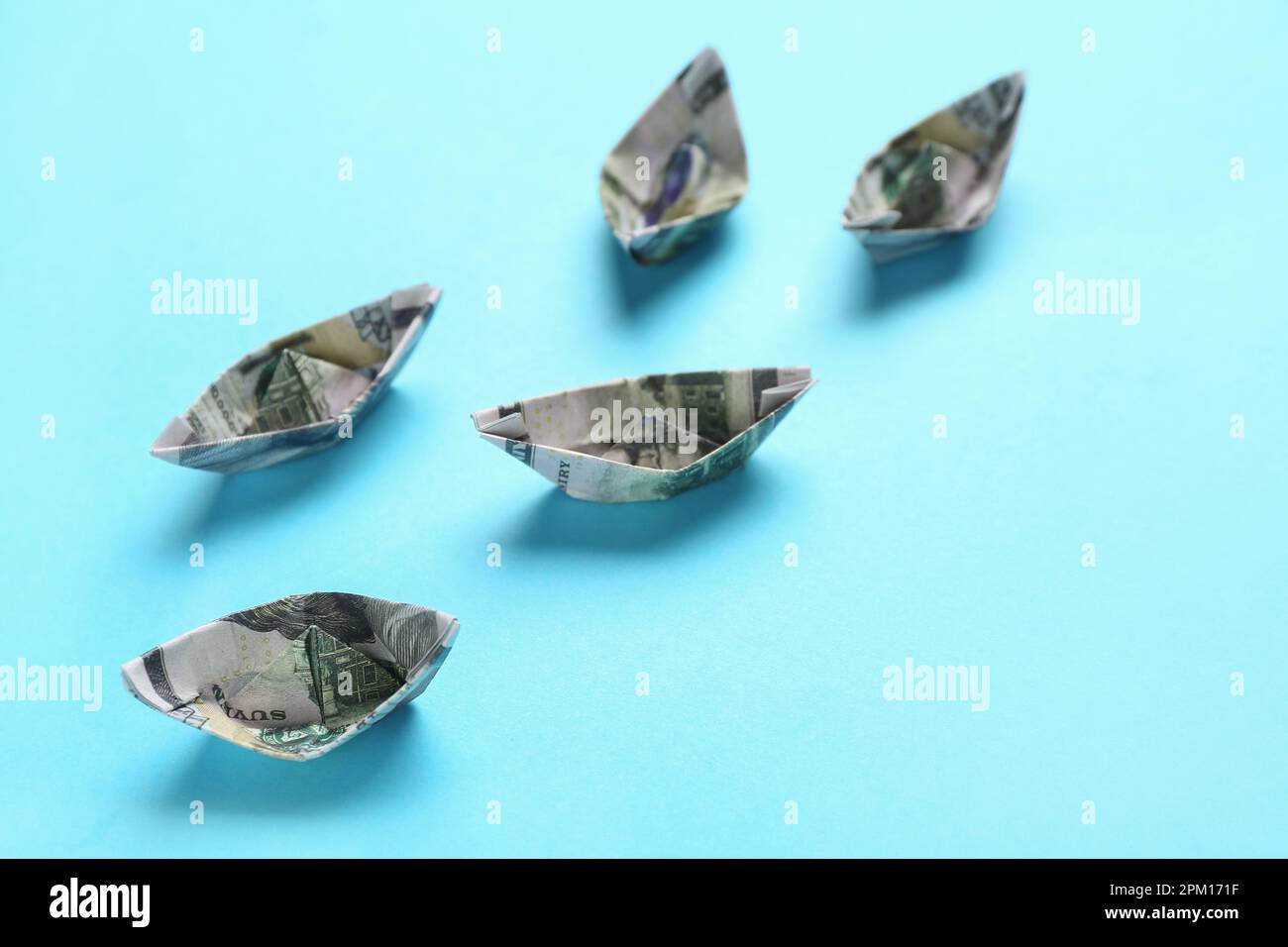 Origami boats made of dollar banknotes on blue background Stock Photo ...