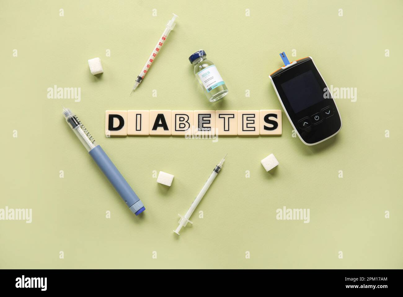 Word DIABETES with glucometer, insulin, lancet pen and sugar on green ...
