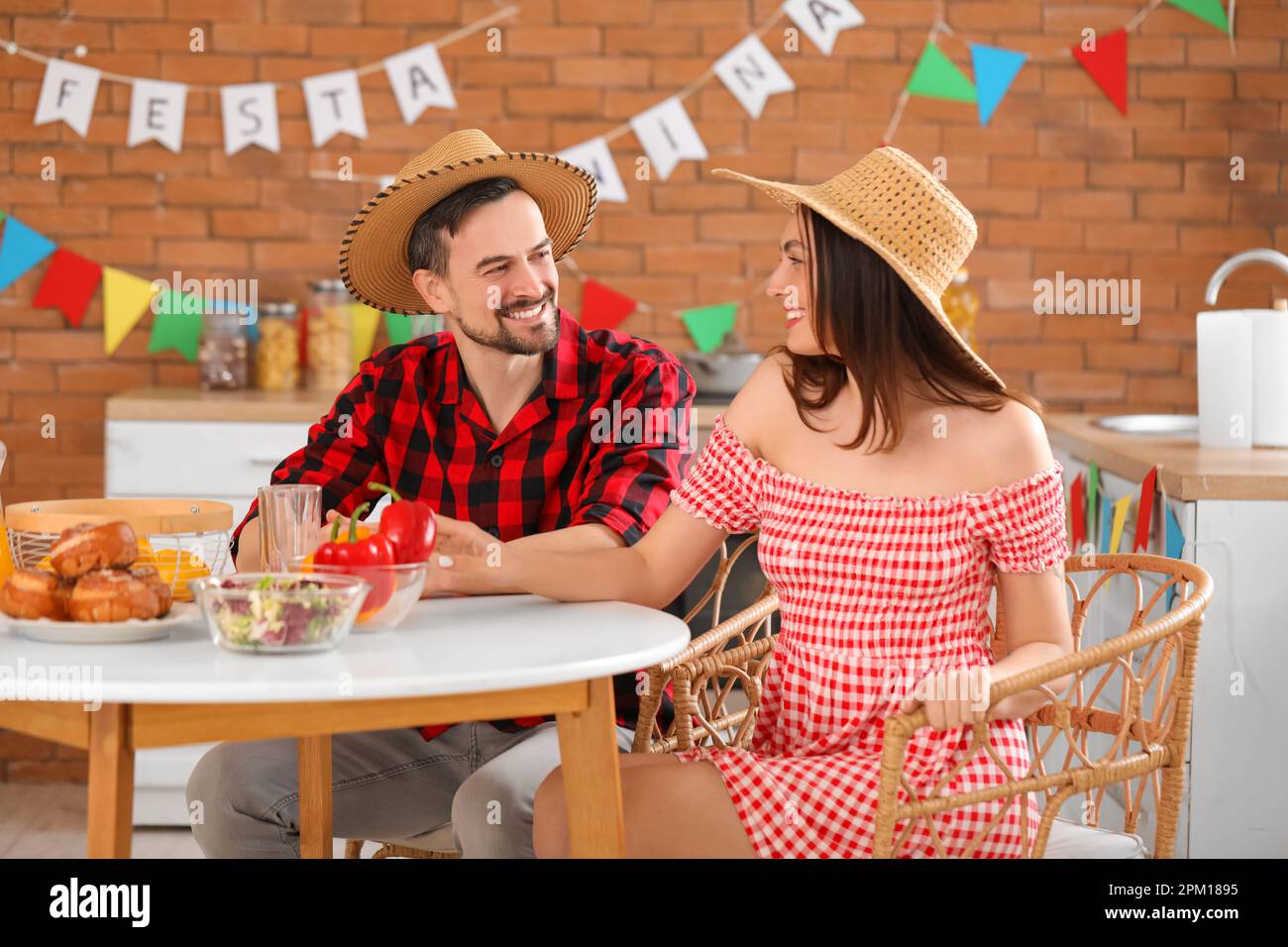Young couple celebrating Festa Junina (June Festival) in kitchen Stock ...