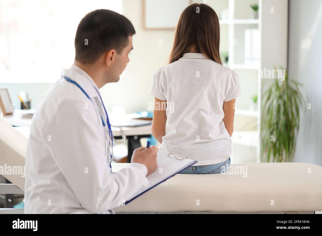 Doctor checking posture of little girl in clinic Stock Photo - Alamy