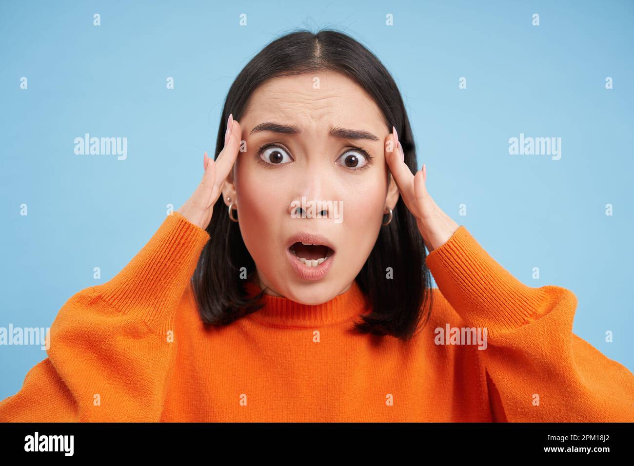 Close up of shocked asian woman in panic, anxious, looks terrified ...