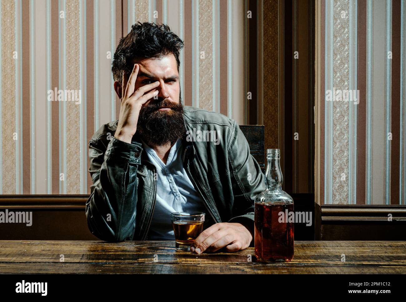 Bearded brutal hipster man drinking expensive cognac. Serious problems ...