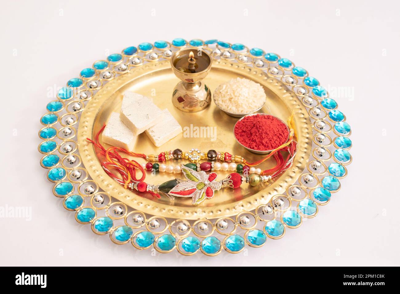 Rakhi with roli chawal and mithai in thali on white background Stock ...
