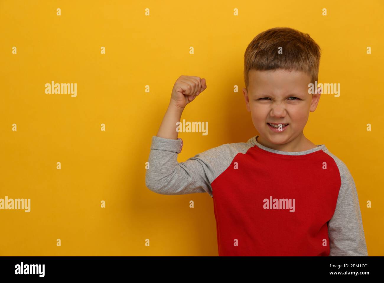Angry little boy on yellow background, space for text. Aggressive ...