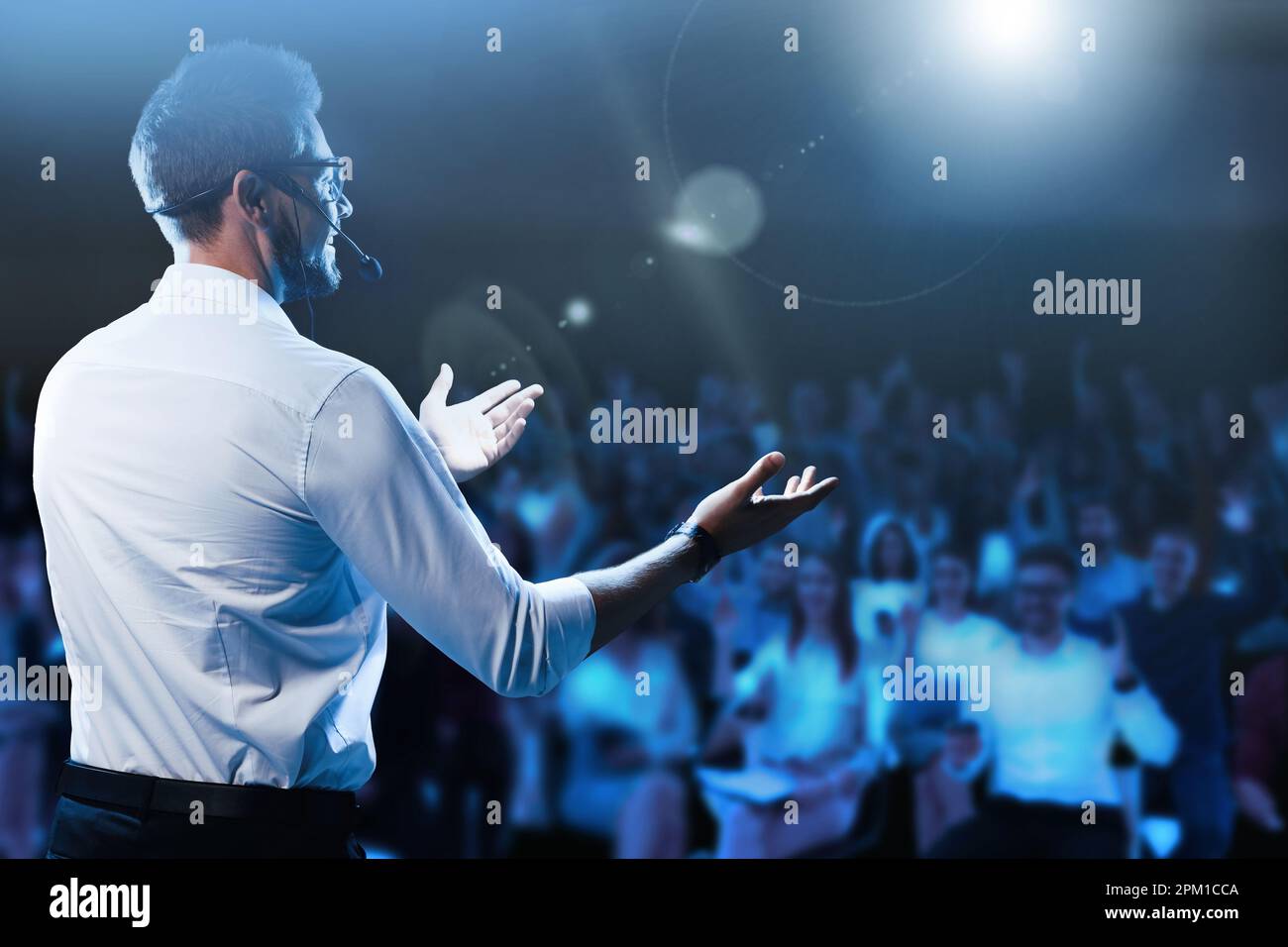 Motivational speaker with headset performing on stage Stock Photo - Alamy
