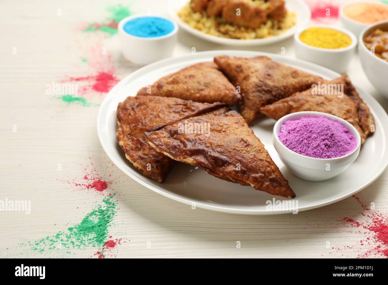 Traditional Indian food and color powders on white wooden table. Holi ...