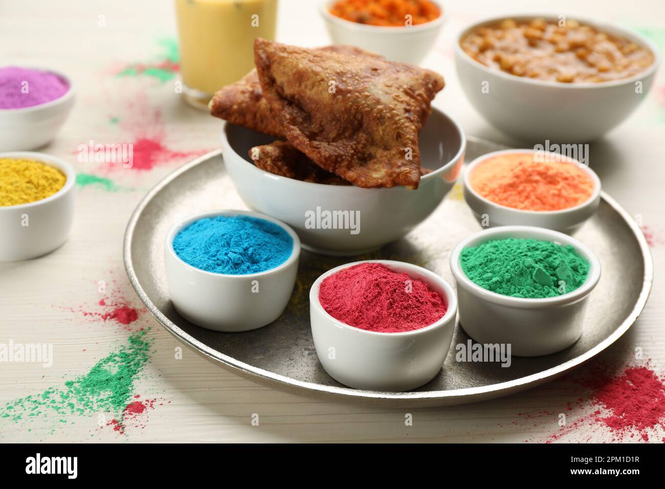 Traditional Indian food and color powders on white wooden table ...