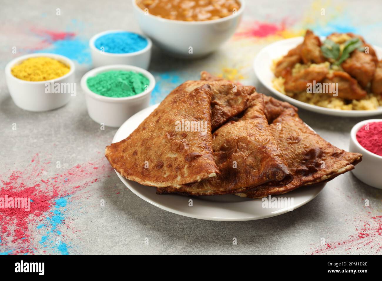 Traditional Indian food and color powders on grey table. Holi festival ...