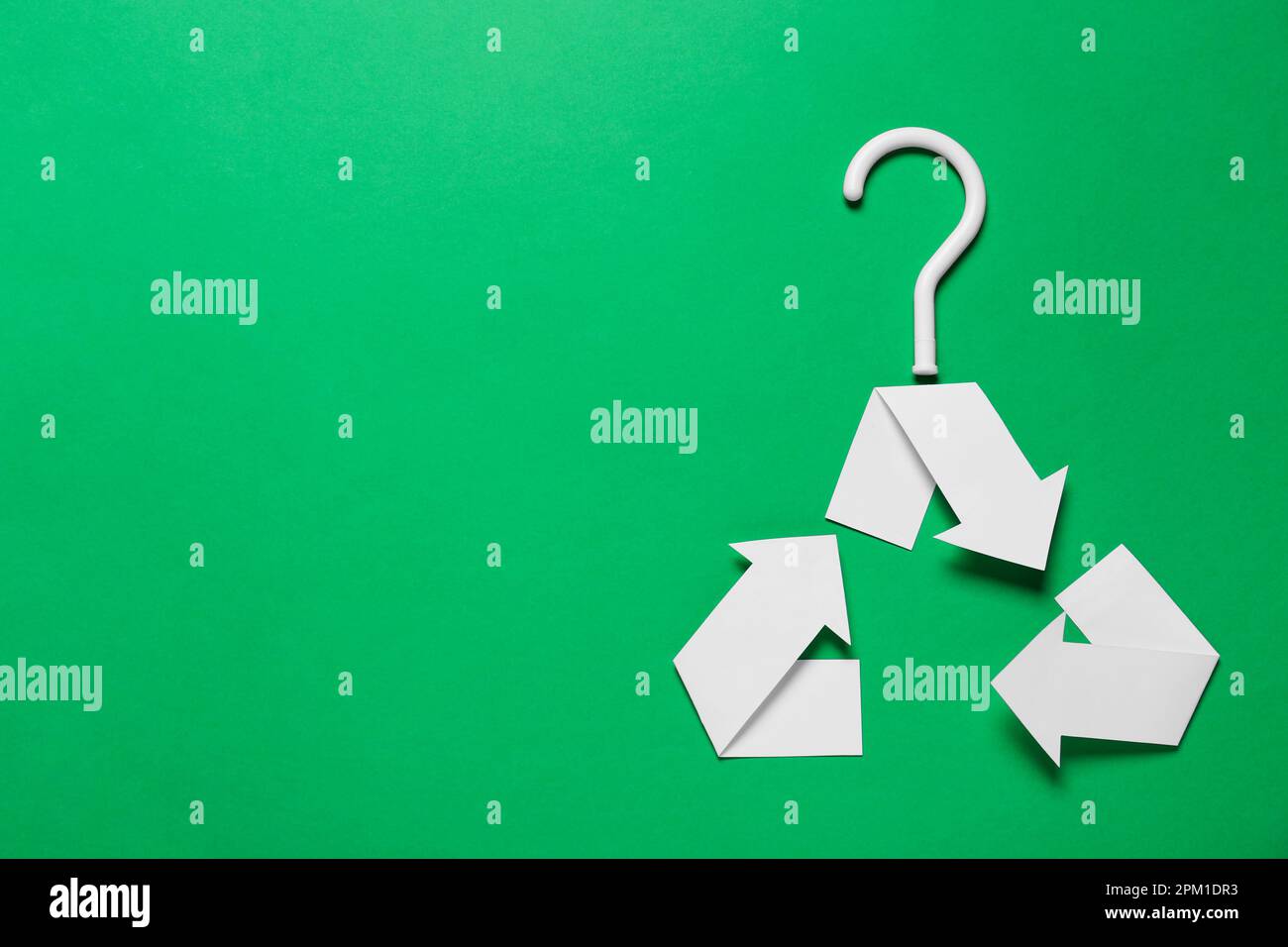 Recycling symbol in shape of hanger on green background, top view ...