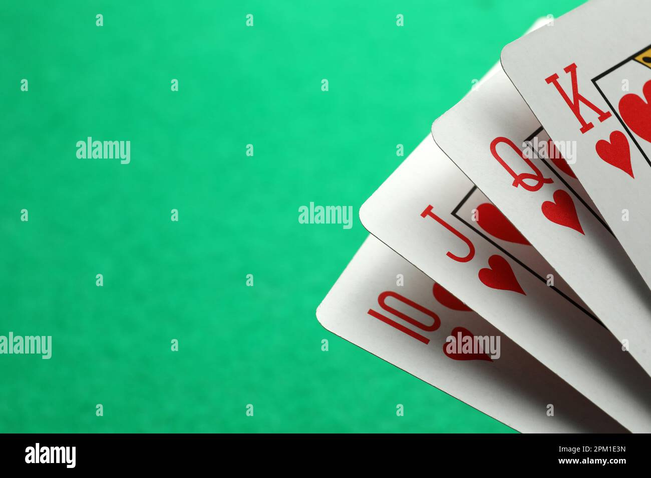 Hand of playing cards on green background, closeup. Space for text ...