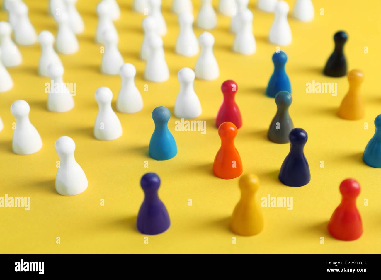 Colorful pawns on yellow background, closeup. Social inclusion concept ...