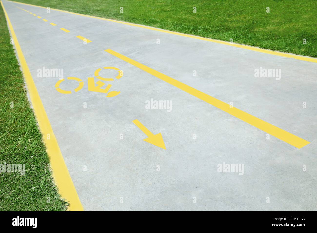 Bike lane with painted yellow bicycle sign and arrow Stock Photo - Alamy