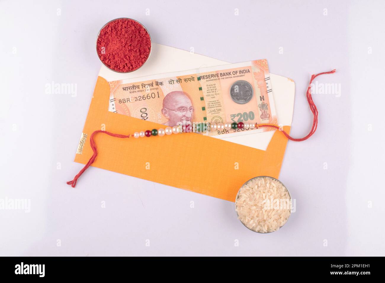 Top view of rakhi with shagun envelope and kumkum on white background ...