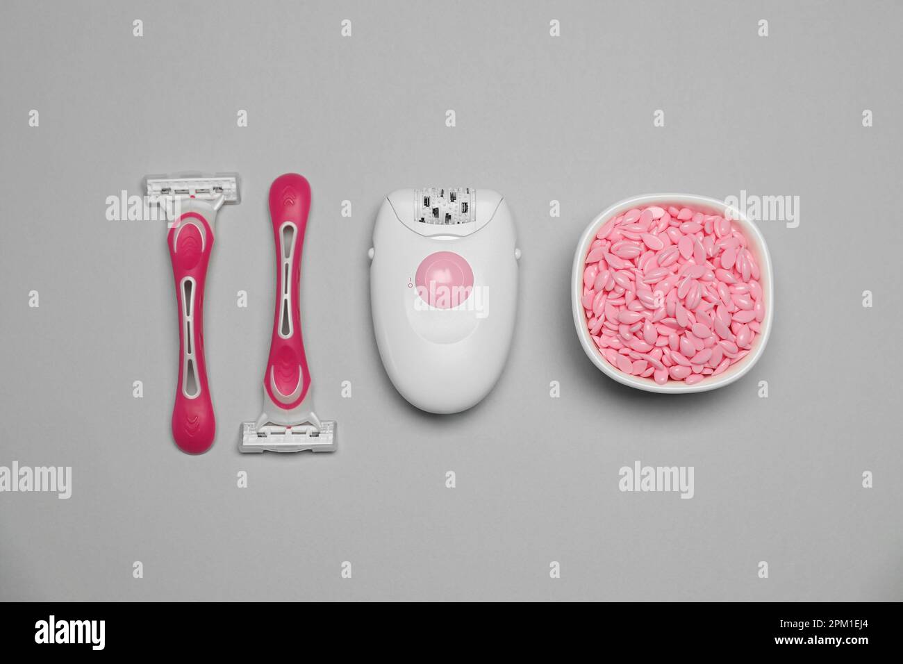 Modern epilator, wax beads and razor on light grey background, flat lay ...