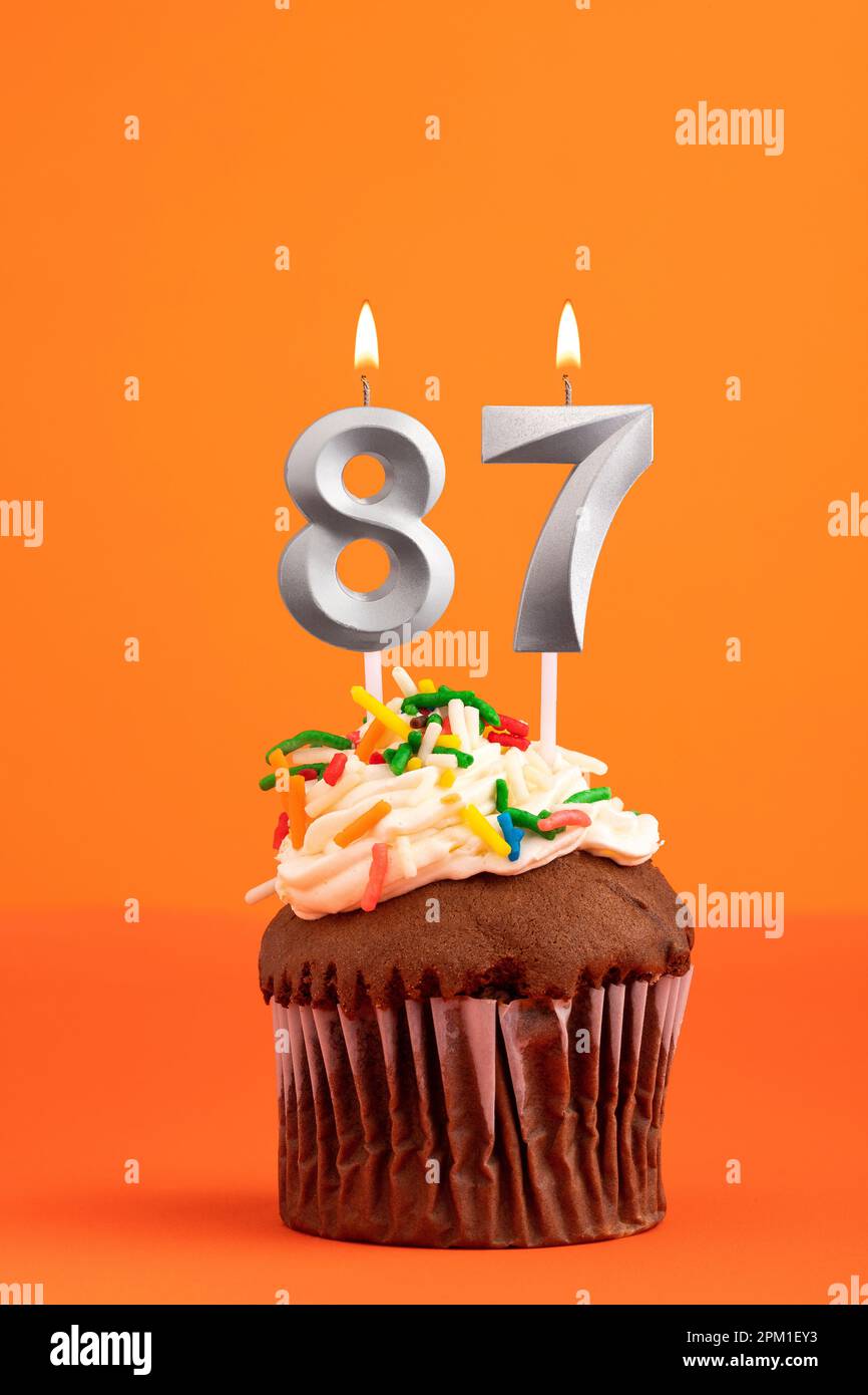 Candle number 87 - Cake birthday in orange background Stock Photo - Alamy
