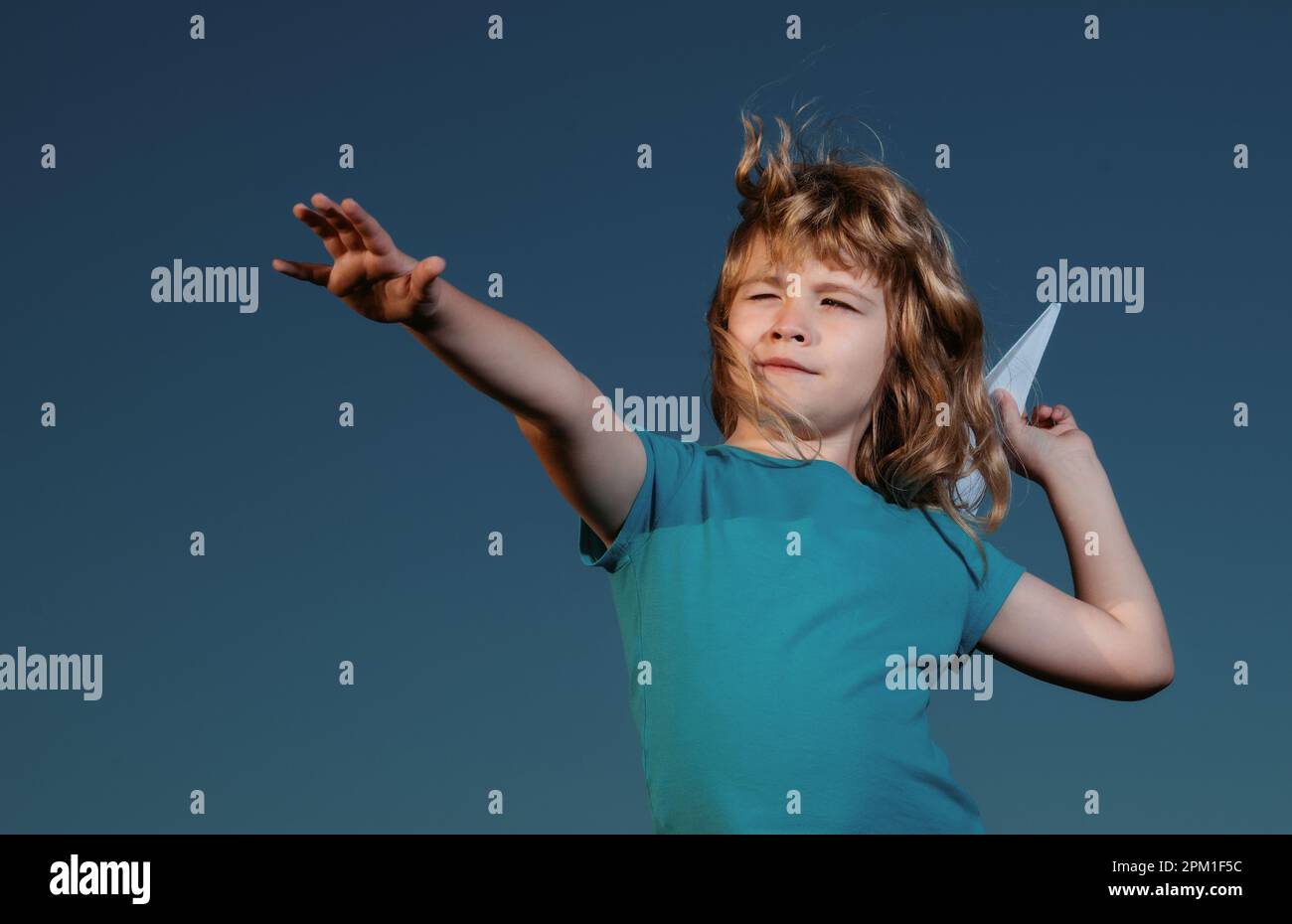 Kid boy throwing a paper plane with blue sky background Stock Photo - Alamy