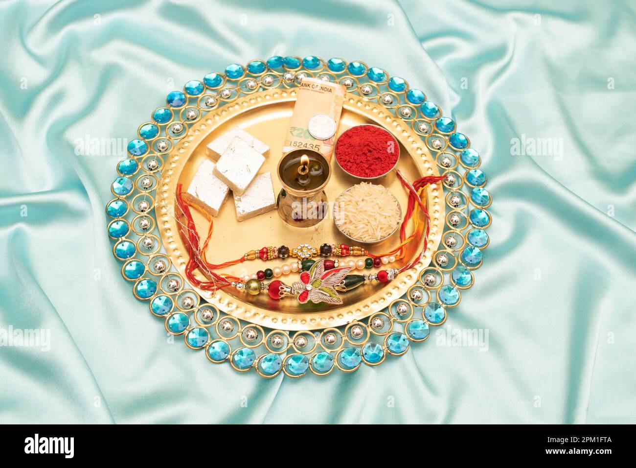 Rakhi with sweets and roli chawal in thali, raksha bandhan concept ...