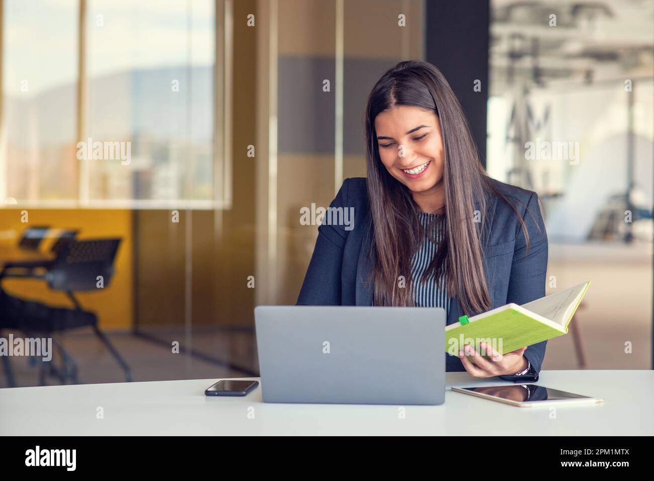 Photo of pretty young girl sit desktop pc hold pen write notepad shirt ...