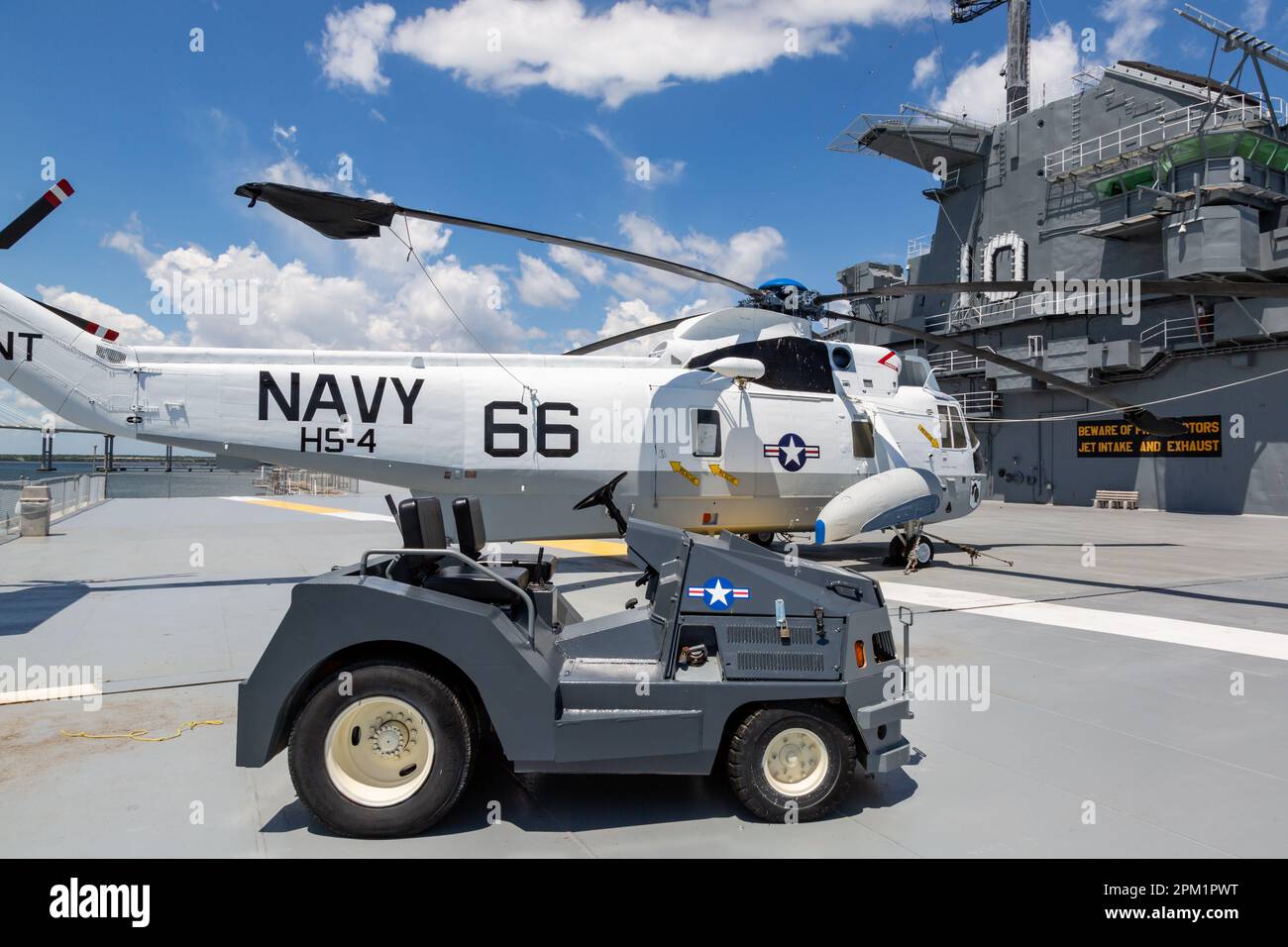 A tug and a US Navy Sikorsky Sea King helicopter on display on the deck ...