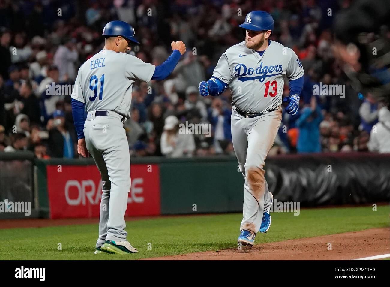 Los Angeles Dodgers' Max Muncy (13) is congratulated by third base ...