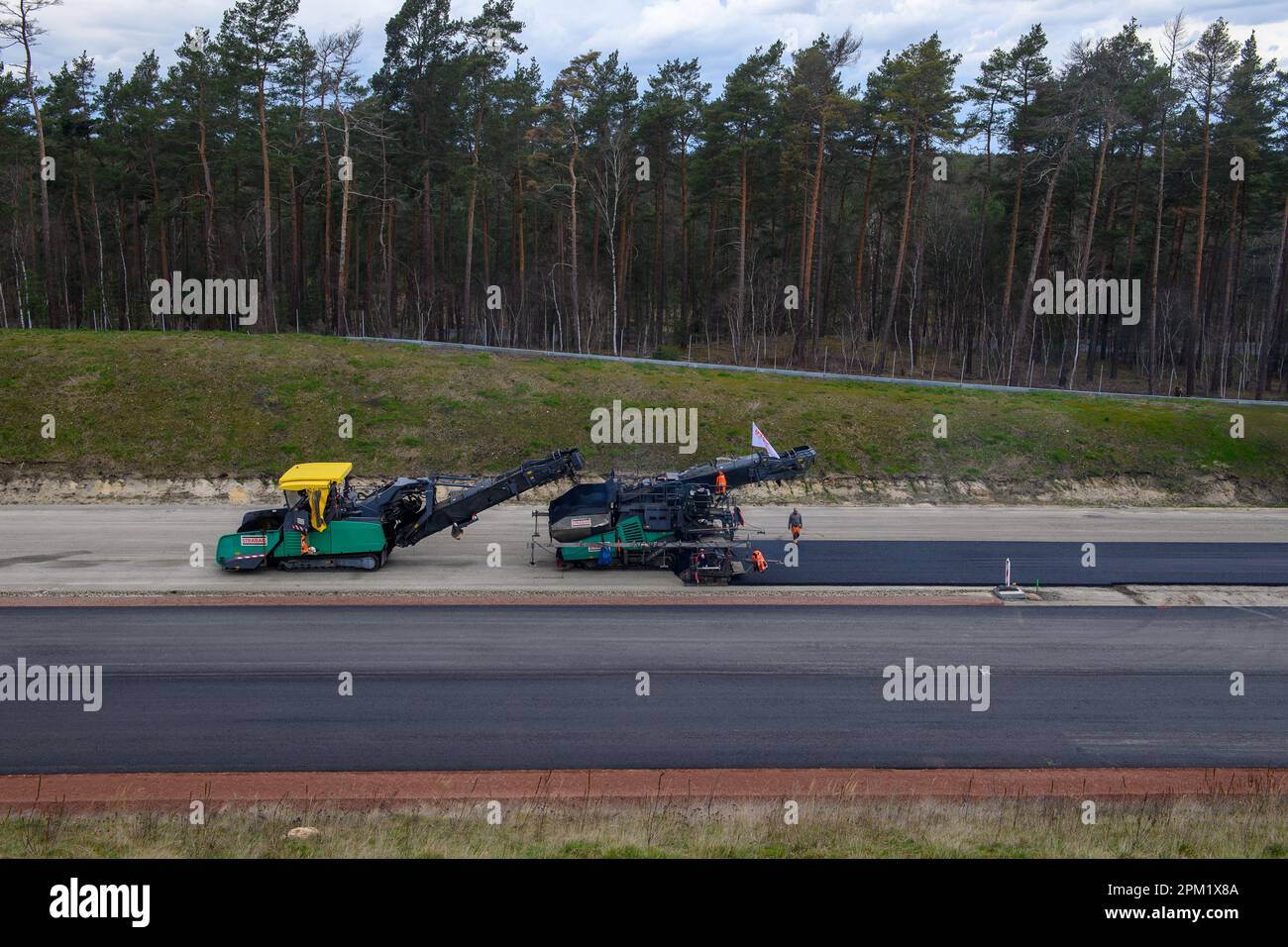 PRODUCTION - 30 March 2023, Saxony-Anhalt, Tangerhütte: Workers asphalt ...