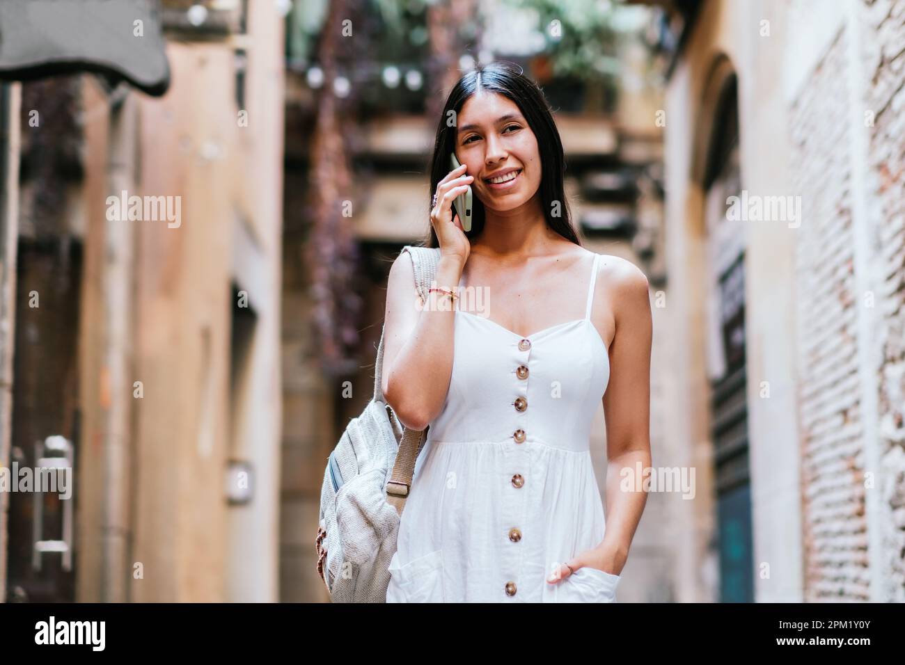 Happy Latin American female traveler with backpack holding hand in ...
