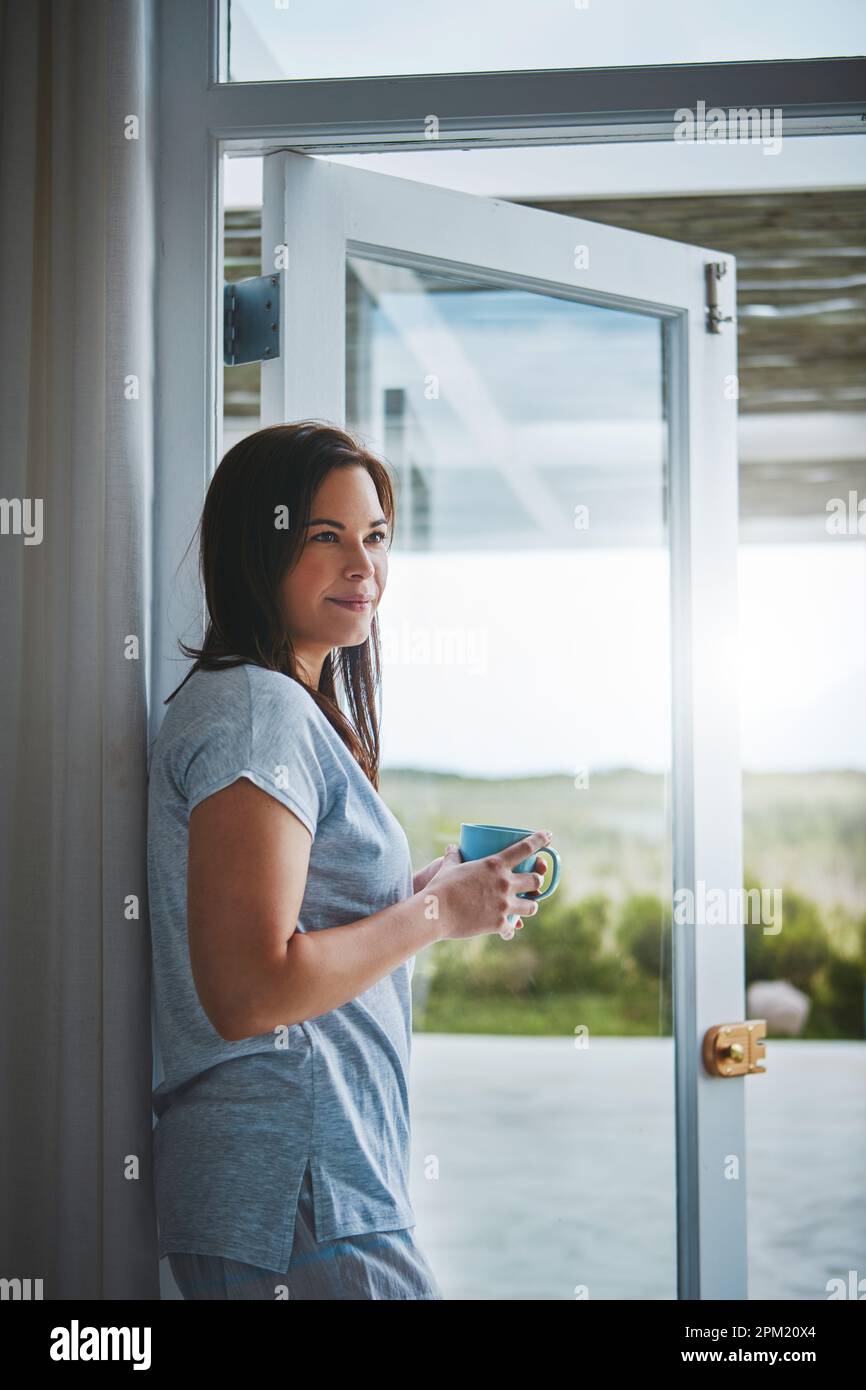 Starting her morning right. an attractive young woman enjoying a coffee ...