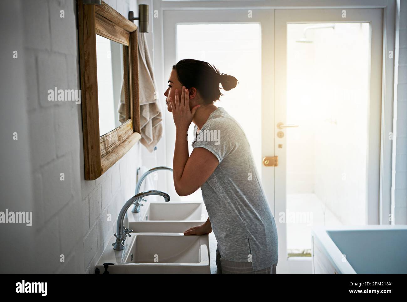 Washing all the sleep off. an attractive young woman washing in the ...