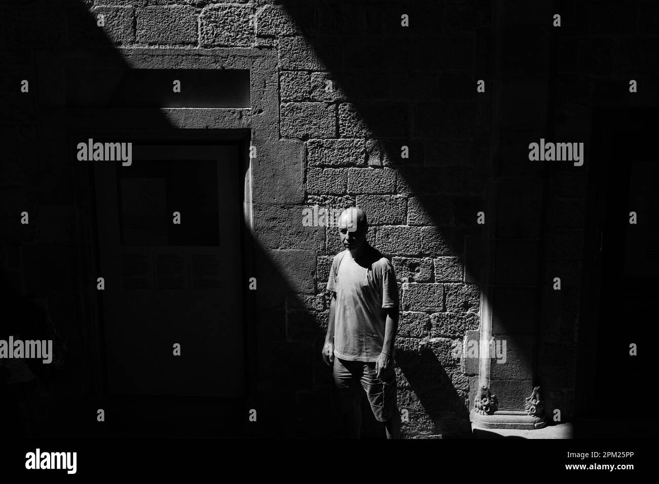 Half-Bust Portrait of a Man in a Diagonal Light Beam Crossing a Stone ...