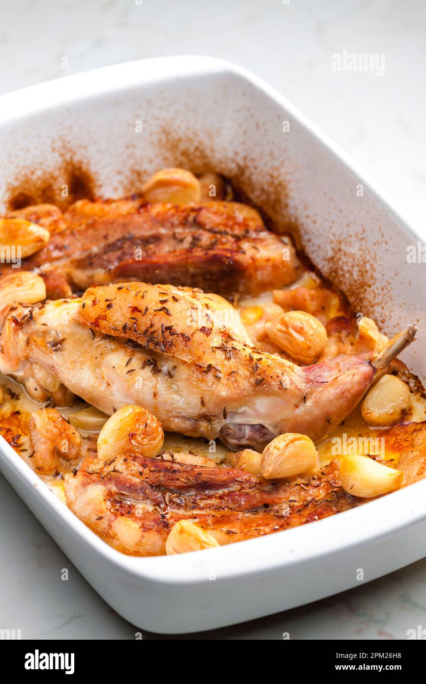 baked rabbit leg with garlic and bacon Stock Photo - Alamy