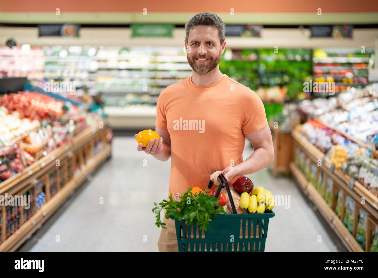 Handsome man with shopping basket with grocery. Man buying groceries in ...