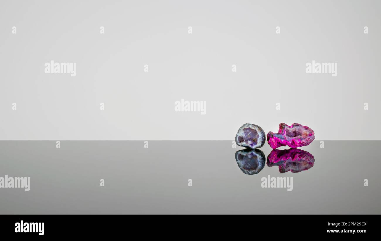 The purple and pink geode rock crystals with their reflection against a ...