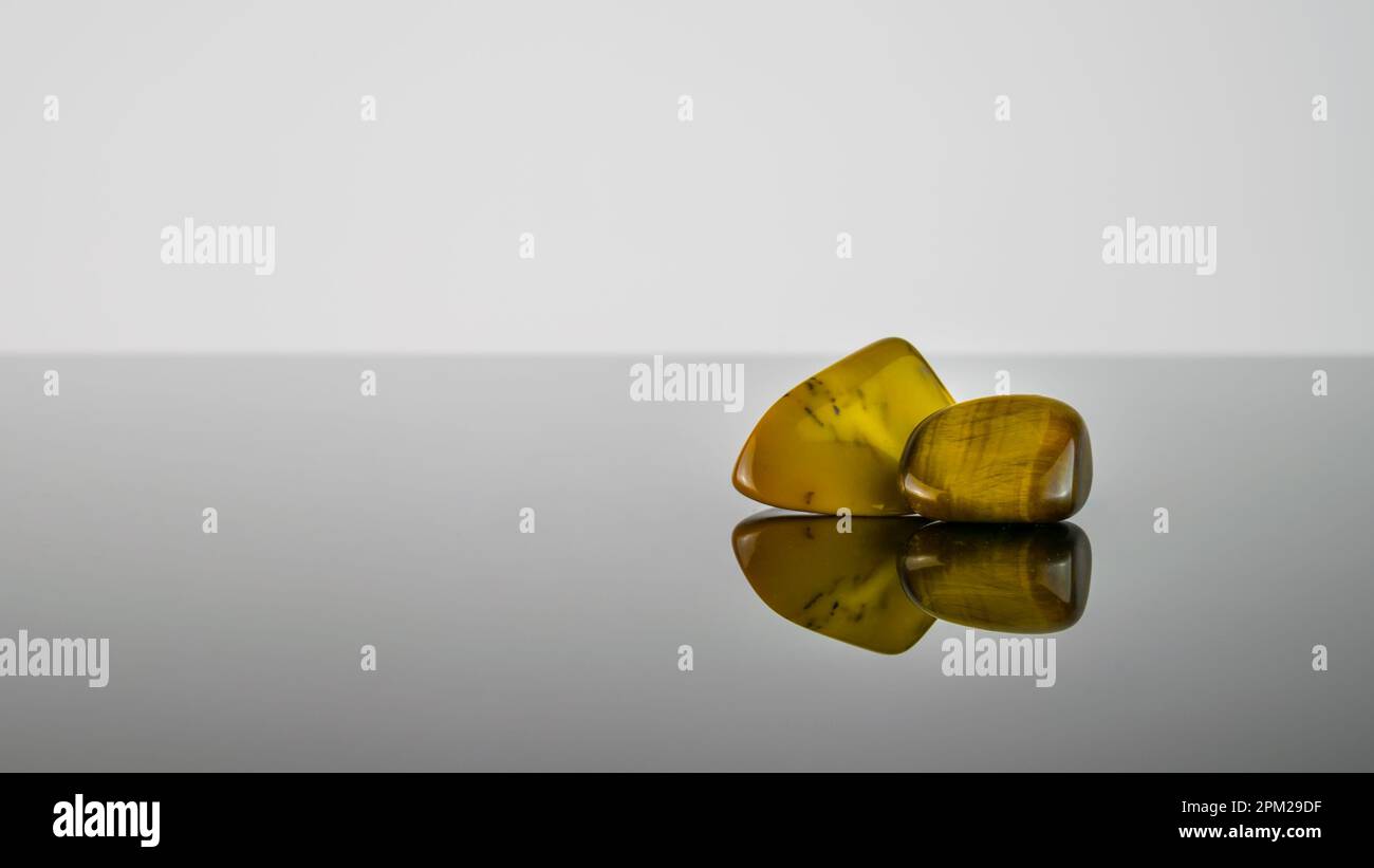The amber rock crystals with their reflection against a grey background ...