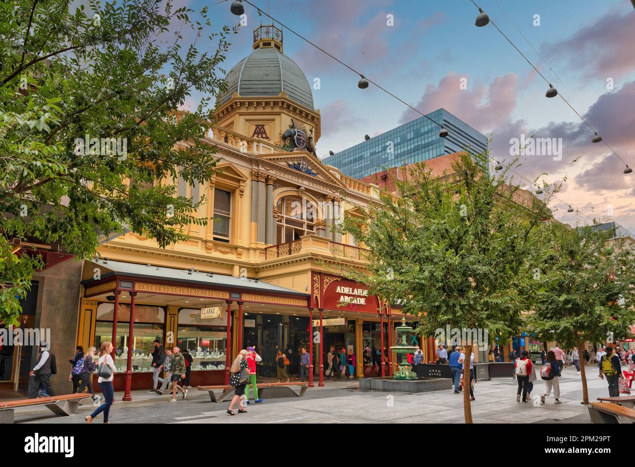 A bustling town square with people walking around the buildings in ...