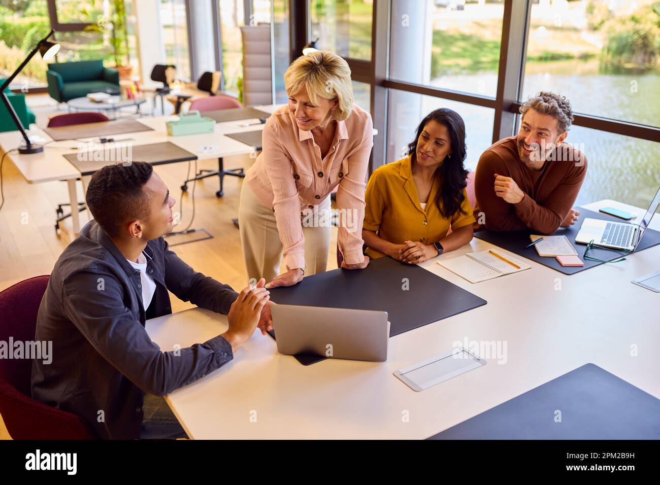 Business team collaborating around desk hi-res stock photography and ...