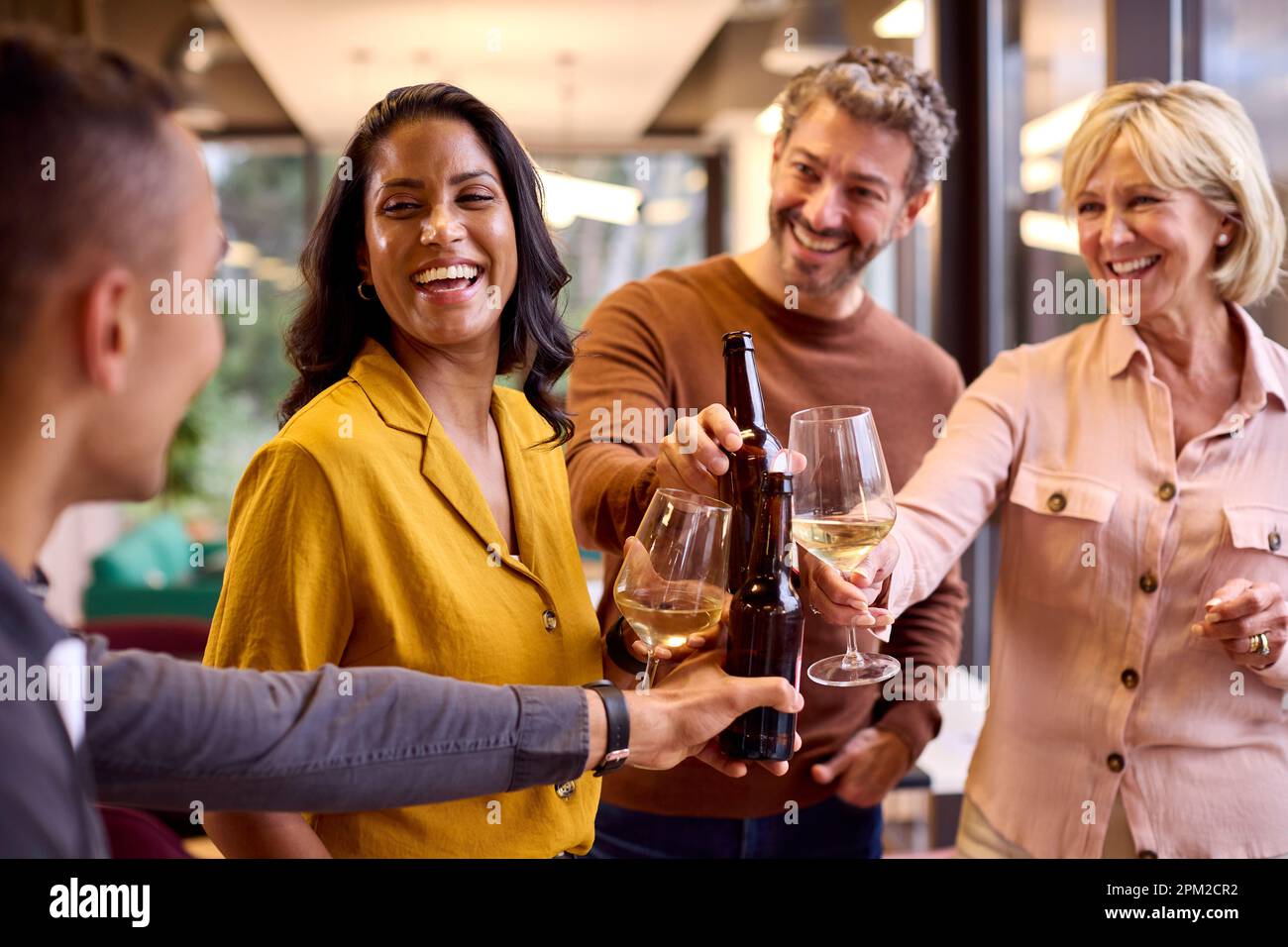 Staff At Informal Team Meeting In Office Celebrating With Drinks Stock ...