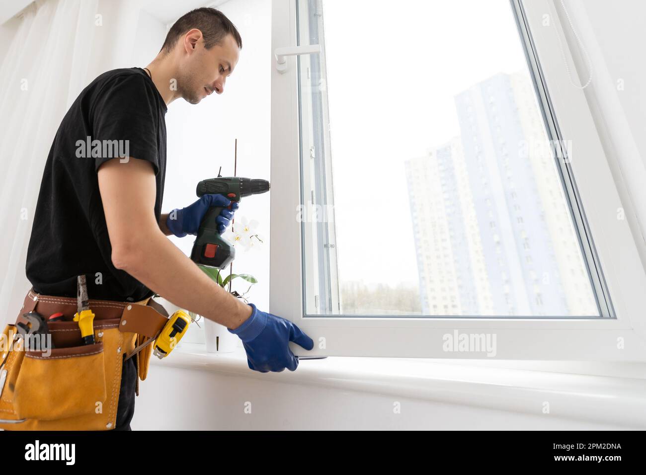 Young repairman fixing window frame in room at daytime Stock Photo - Alamy
