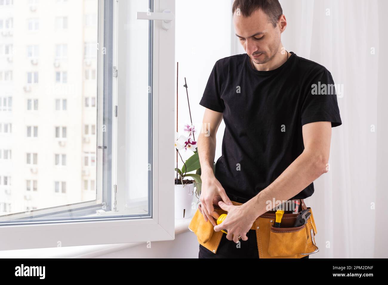 Young repairman fixing window frame in room at daytime Stock Photo - Alamy