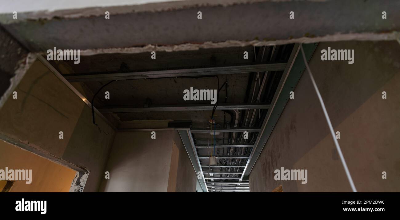 Construction worker assemble a suspended ceiling with drywall and ...