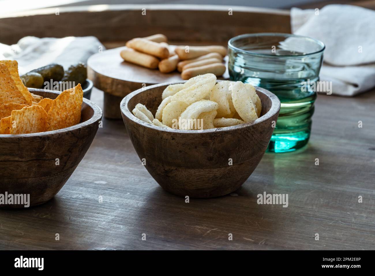 Variety of chips and snacks in bowls on wooden table background Stock ...