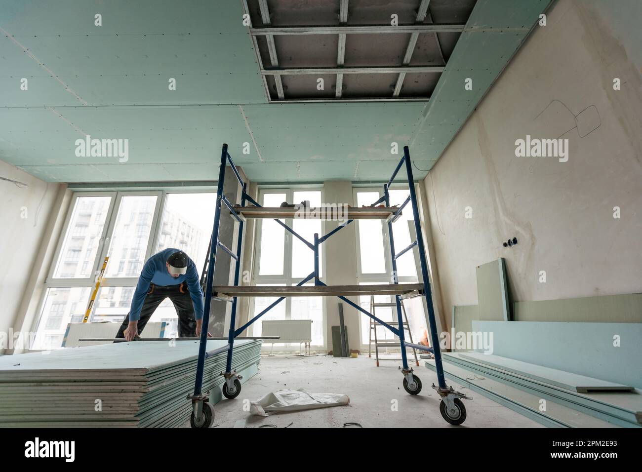 Construction worker installation ceiling work Stock Photo - Alamy